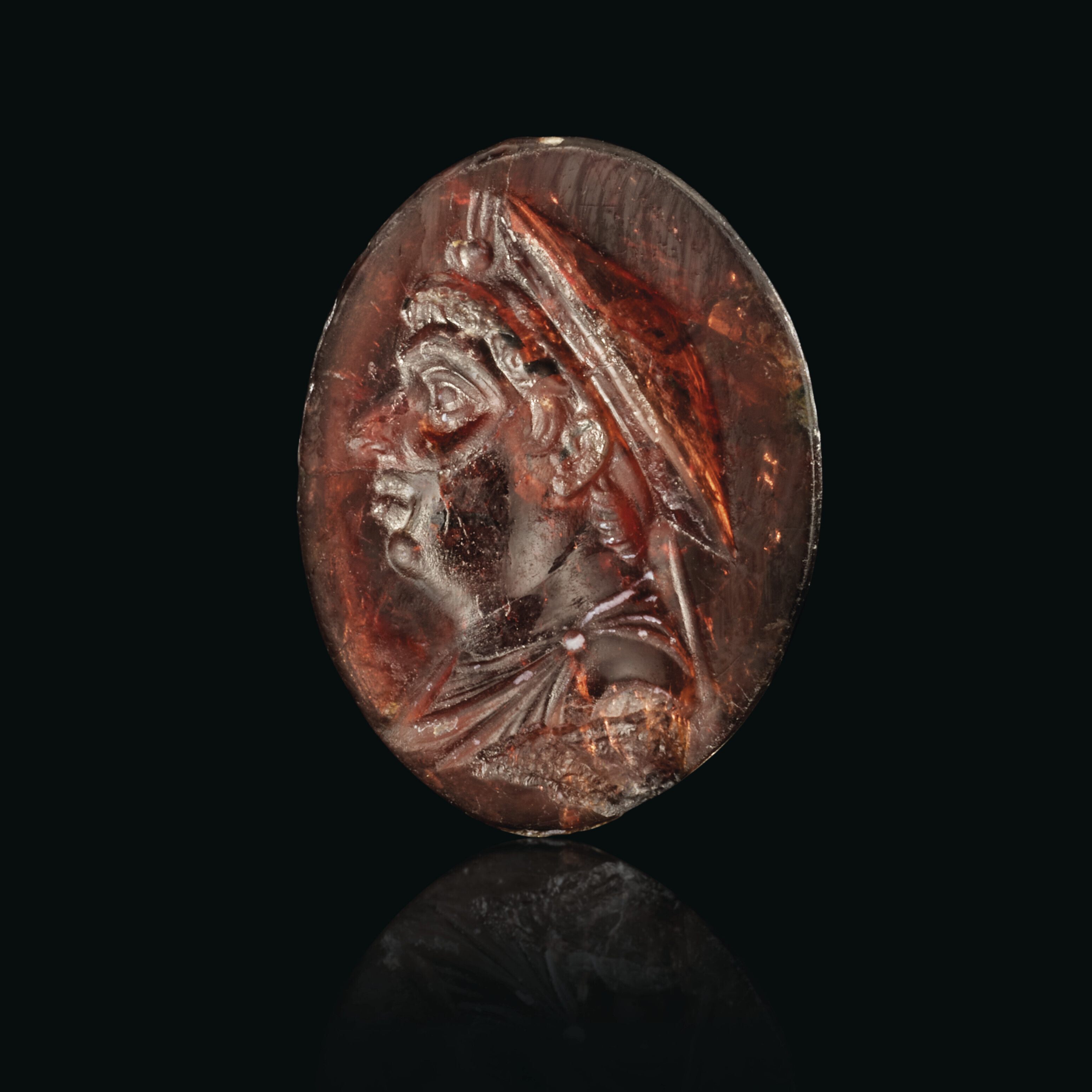 A GREEK CARNELIAN SCARAB WITH A YOUTH LEANING ON A STAFF, ARCHAIC ...