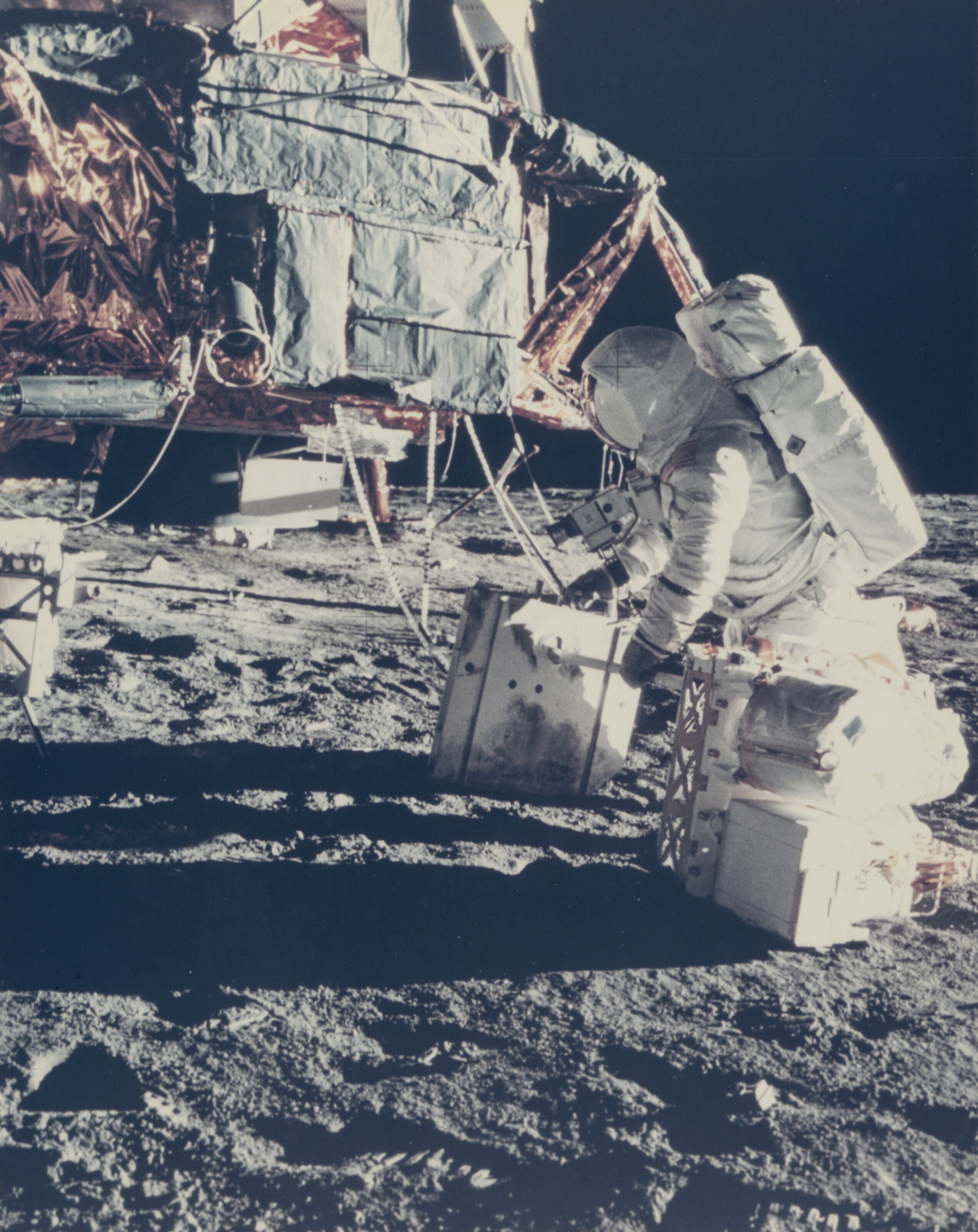 ALAN BEAN PREPARING TO CARRY THE SCIENTIFIC EQUIPMENT TO THEIR ...