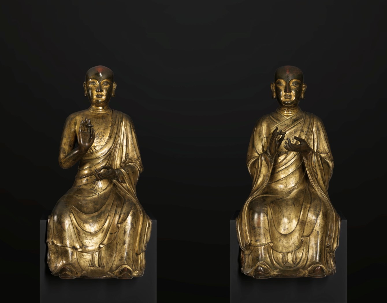 AN EXCEEDINGLY RARE PAIR OF GILT-BRONZE SEATED LUOHAN FIGURES