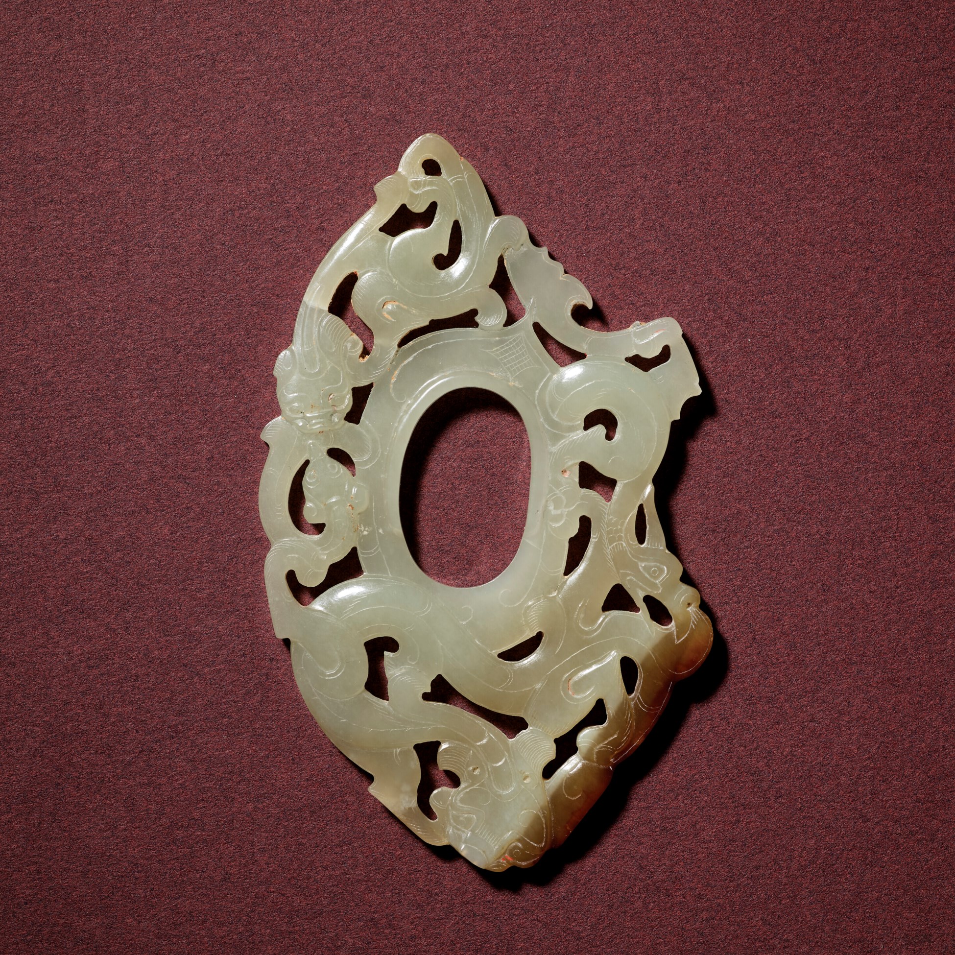 A WHITE JADE ‘CHI DRAGON AND PHOENIX’ RETICULATED PENDANT, LATE WESTERN ...