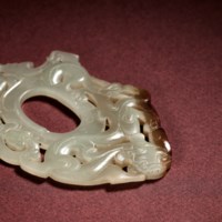 A WHITE JADE ‘CHI DRAGON AND PHOENIX’ RETICULATED PENDANT, LATE WESTERN ...