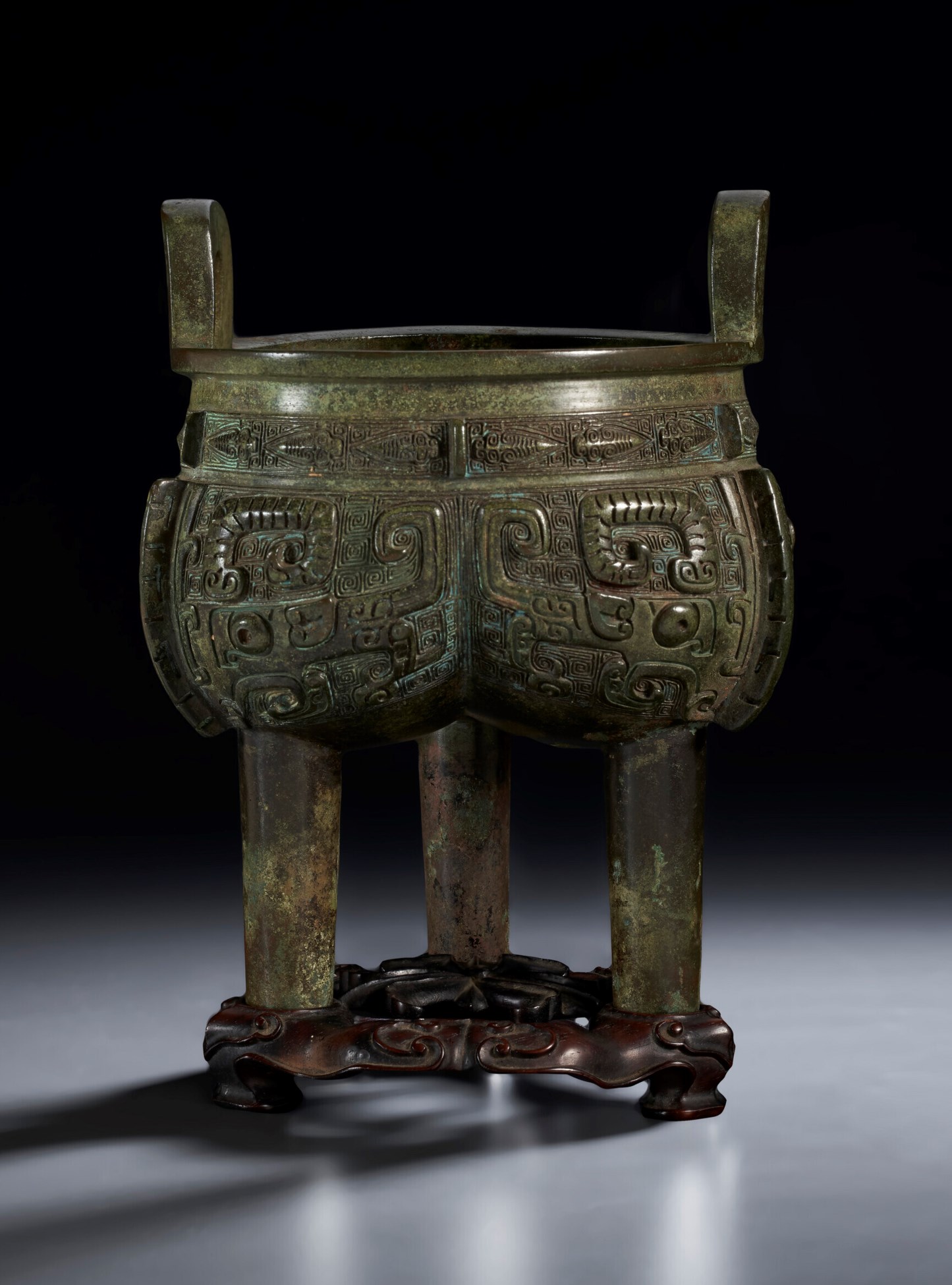 A SUPERBLY CAST BRONZE RITUAL TRIPOD FOOD VESSEL, LIDING, LATE SHANG ...