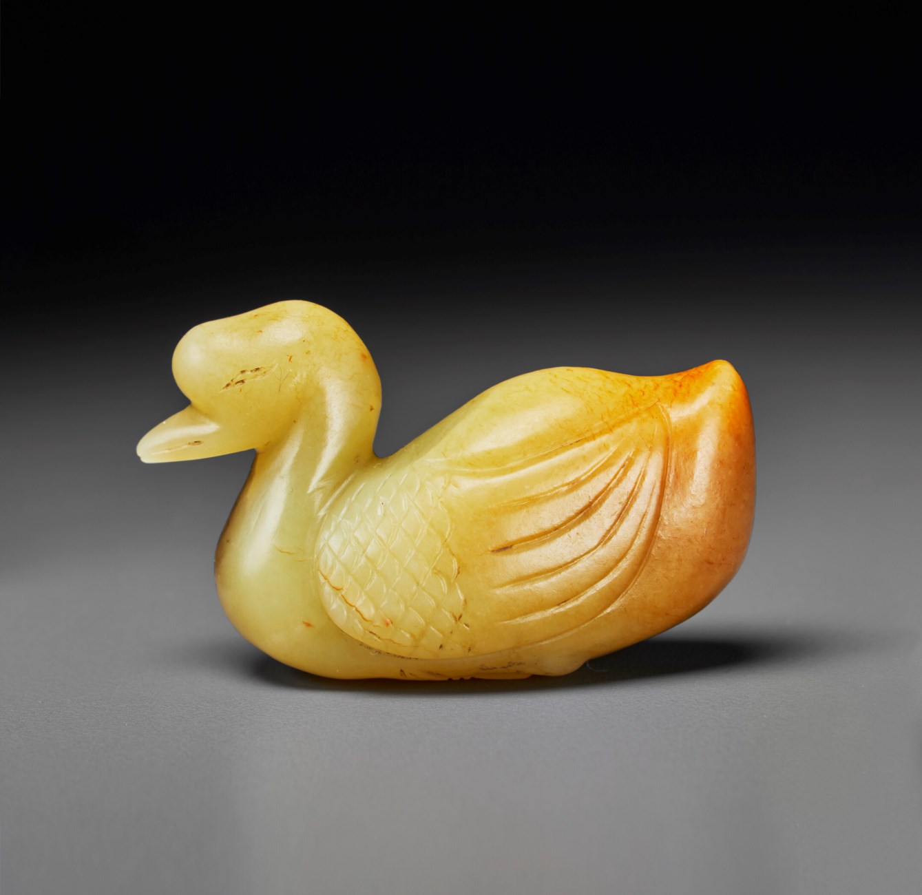 A YELLOW AND RUSSET JADE FIGURE OF A GOOSE