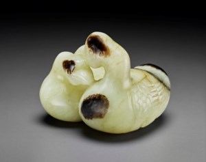 A PALE CELADON AND BLACKISH-BROWN JADE CARVING OF TWO RECUMBENT GEESE ...