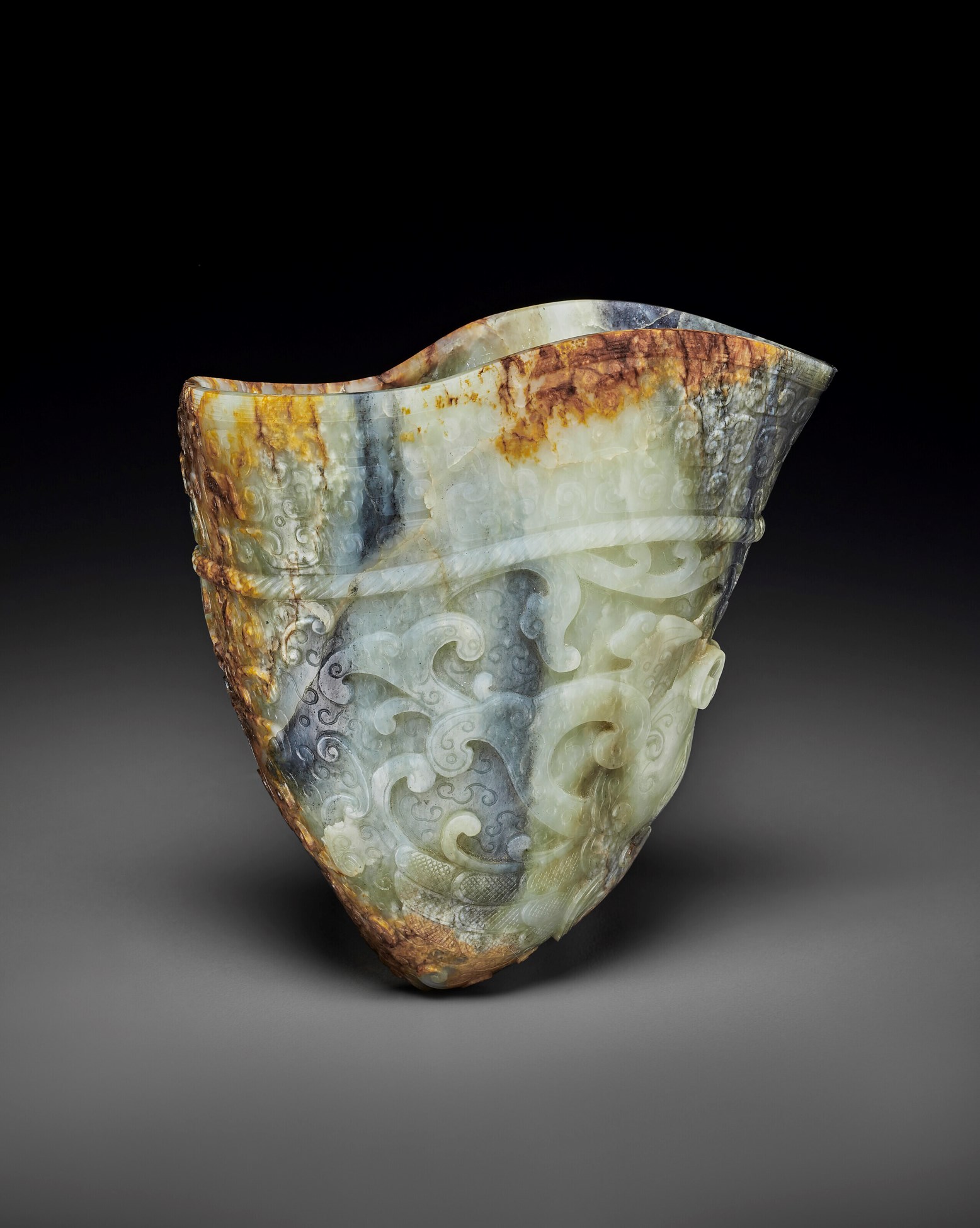 A VERY RARE IMPERIALLY INSCRIBED GREY, RUSSET AND BLACK JADE RHYTON ...