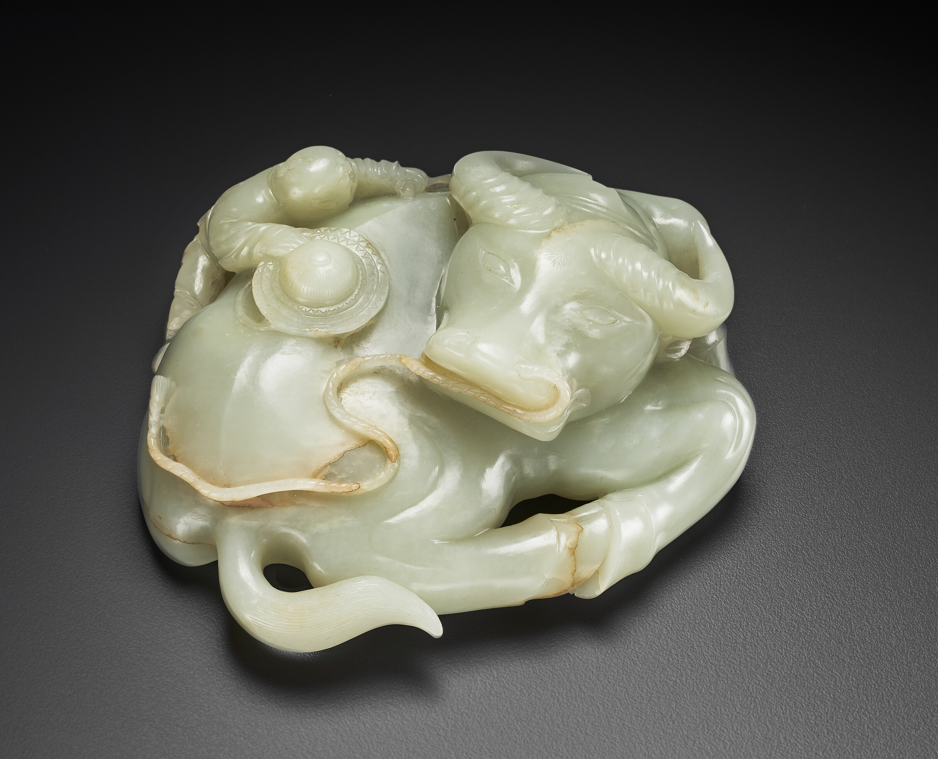 A BROWN AND OLIVE-GREEN JADE FIGURE OF A RECUMBENT CAMEL, MING-QING ...