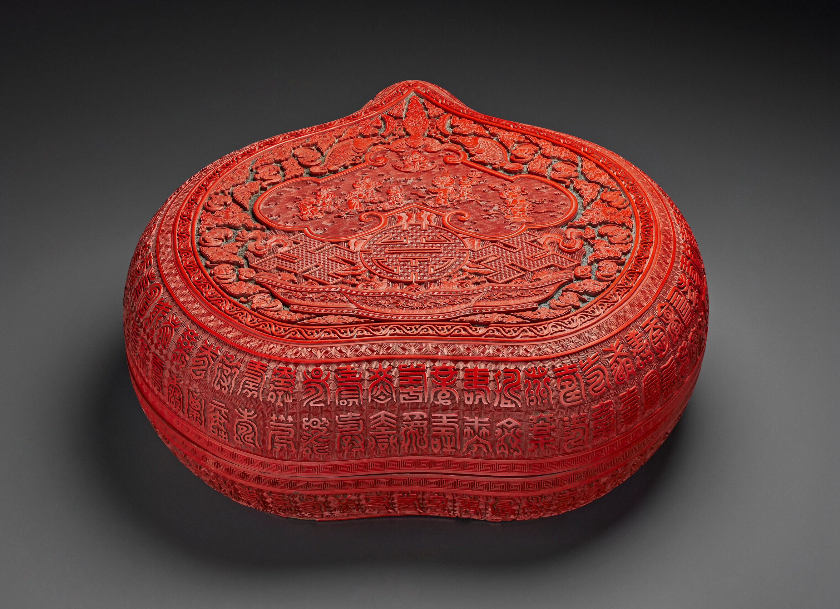 A VERY RARE LARGE CARVED RED AND BLACK LACQUER PEACH-FORM `SHOU’ BOX ...