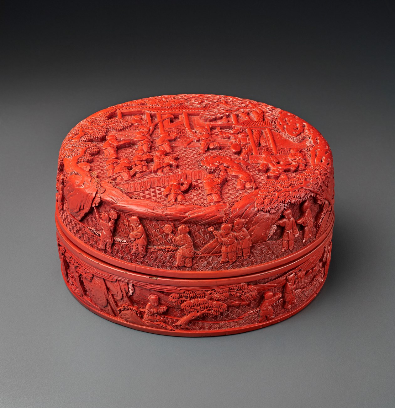 A RARE AND FINELY CARVED RED LACQUER `HUNDRED BOYS’ CIRCULAR BOX AND ...