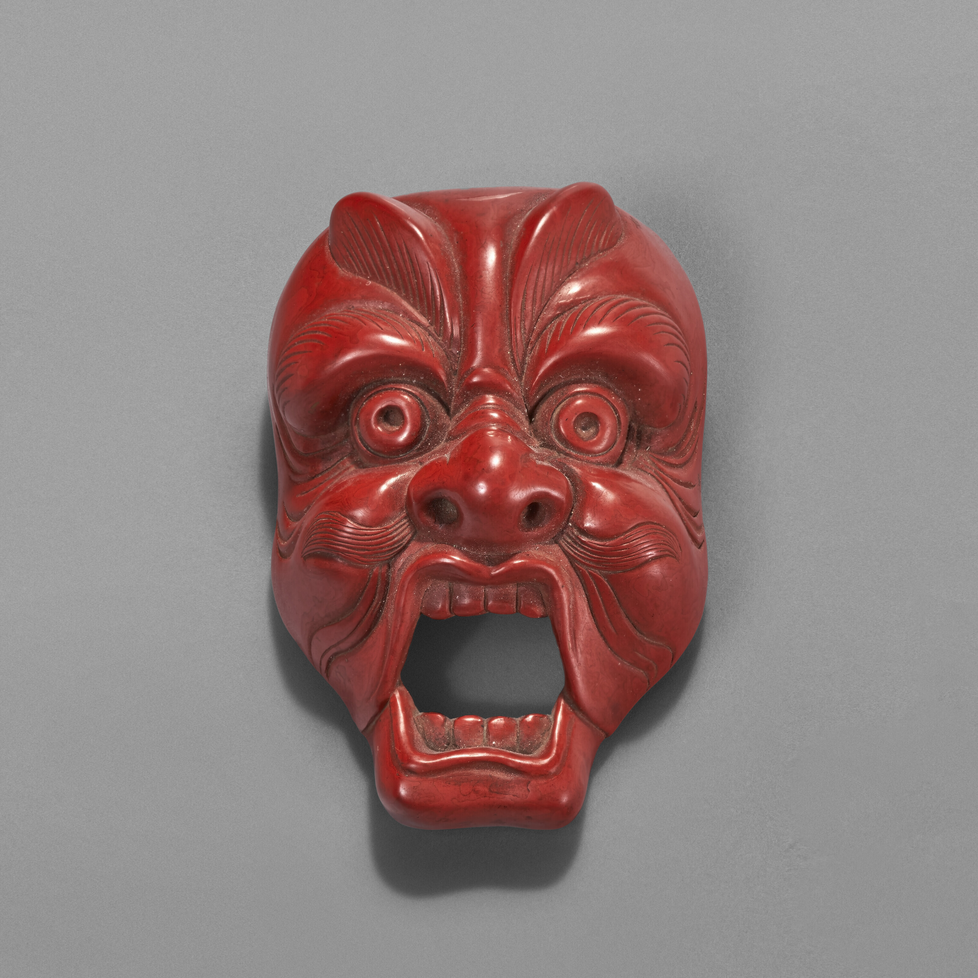 A CARVED LACQUER SCULPTURE (NETSUKE) OF A GENJORAKU MASK, EDO PERIOD ...