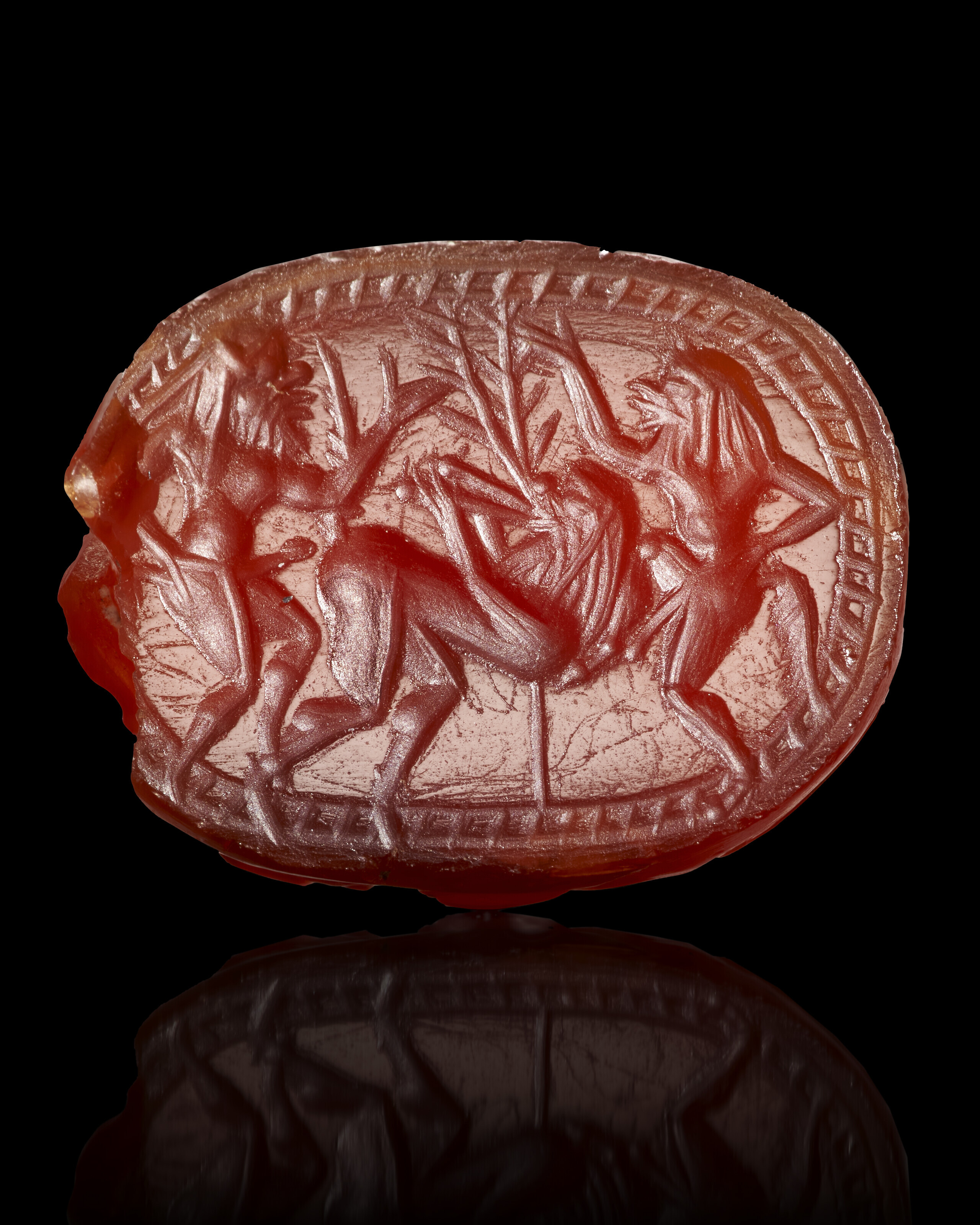 A GREEK CARNELIAN SCARAB WITH SATYRS, ARCHAIC PERIOD, CIRCA 525 B.C ...