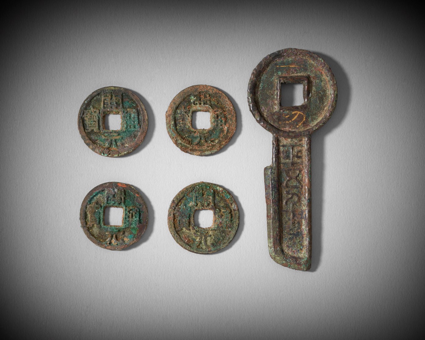 A GROUP OF FIVE BRONZE COINS, XIN DYNASTY (AD 9-24) AND TANG DYNASTY ...
