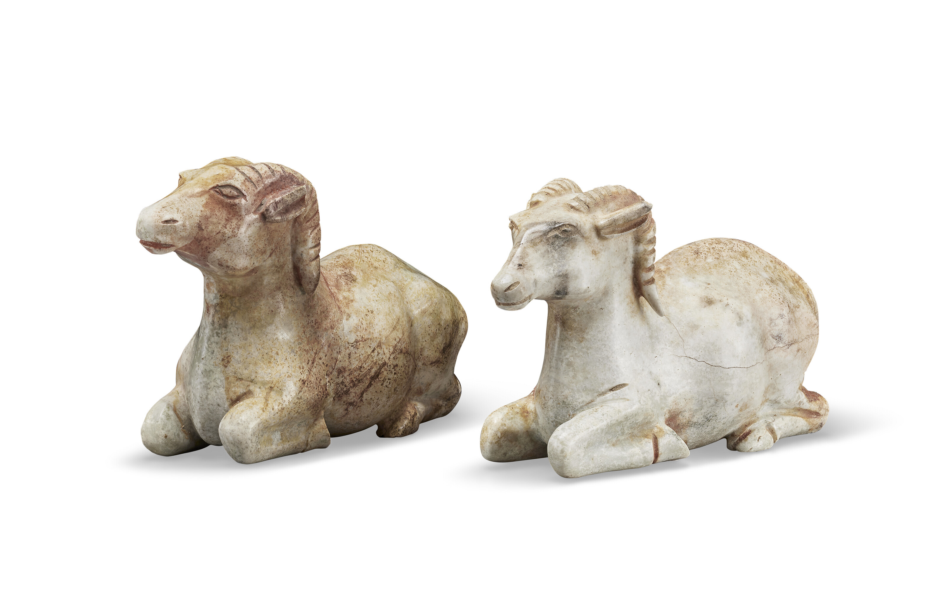 A PAIR OF MOTTLED GREYISH-WHITE JADE FIGURES OF RECUMBENT RAMS, CHINA ...