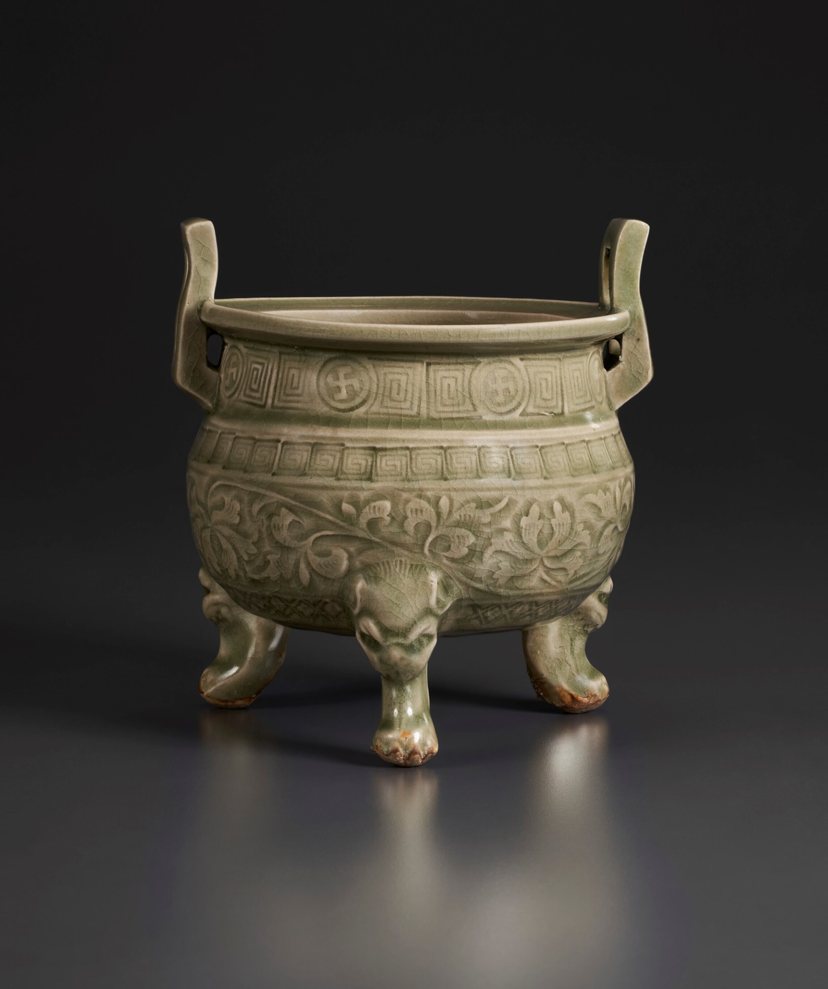 AN UNUSUAL CARVED AND MOLDED YAOZHOU CELADON TRIPOD CENSER, NORTHERN ...