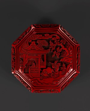 A CARVED RED LACQUER OCTAGONAL FOUR-TIERED BOX AND COVER