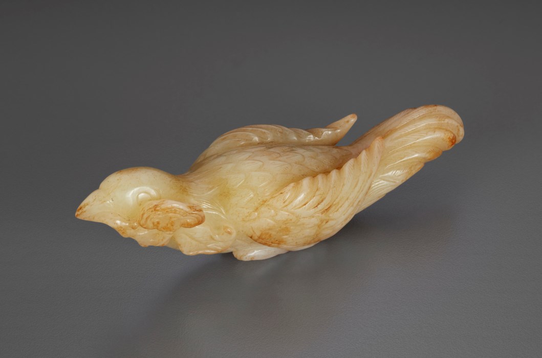 A YELLOWISH-BEIGE JADE FIGURE OF A BIRD