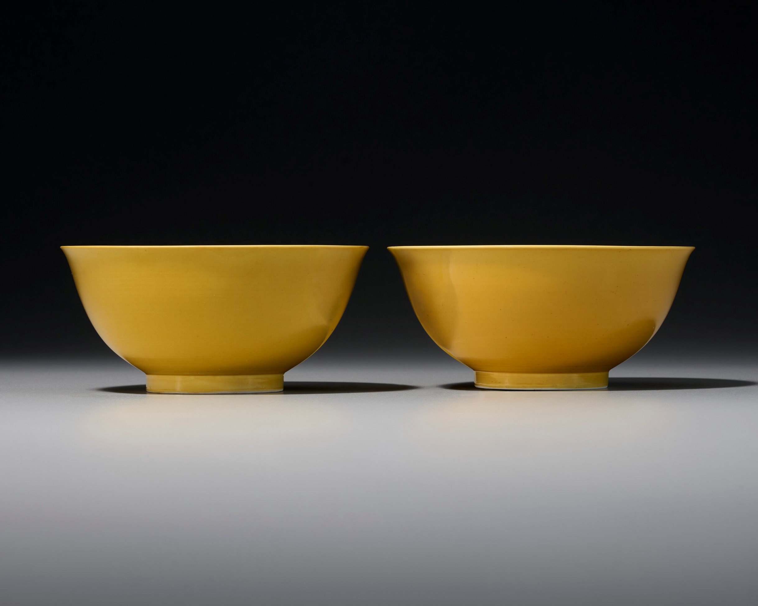 TWO YELLOW-GLAZED BOWLS, QIANLONG SEAL MARKS IN UNDERGLAZE BLUE AND OF ...
