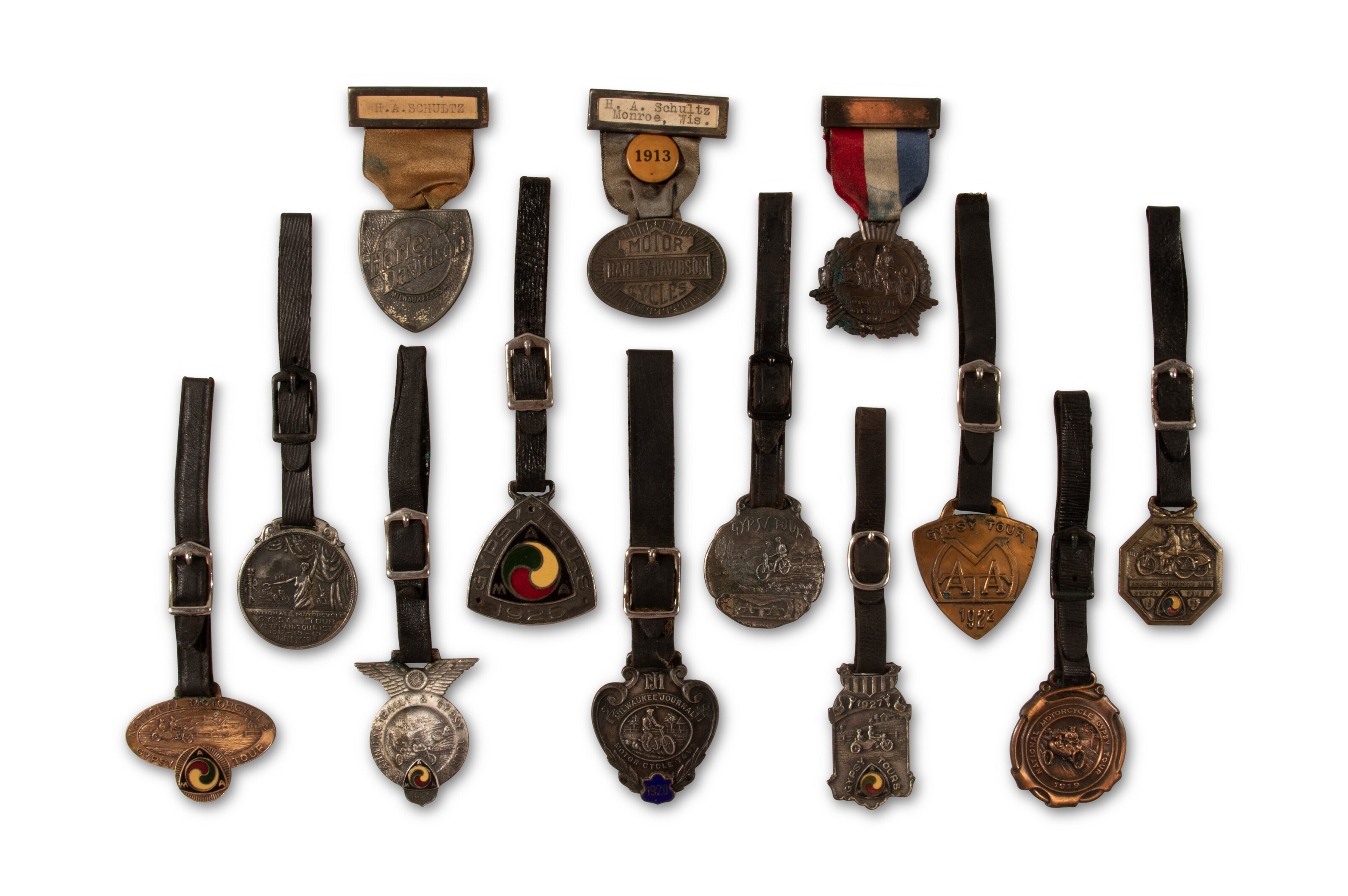 A COLLECTION OF THIRTEEN MOTOR CYCLE RELATED PINS AND FOBS INCLUDING ...