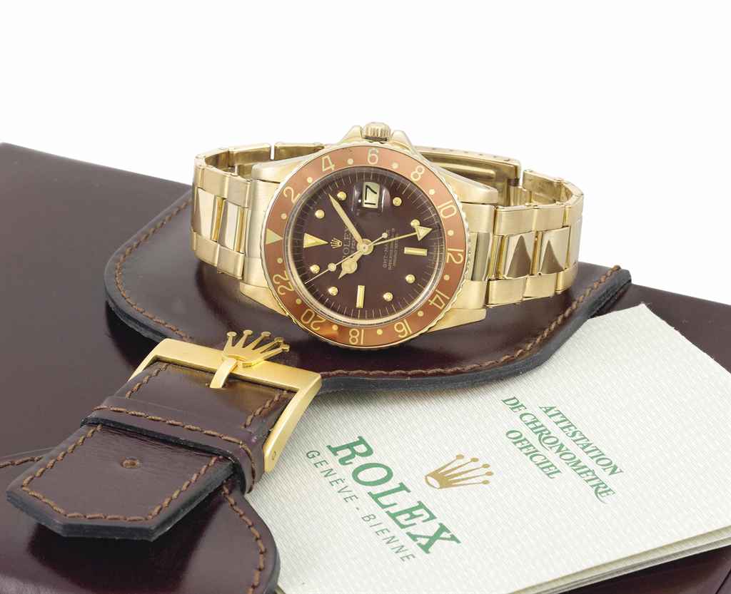 Rolex A fine and rare 18K gold automatic dual time wristwatc ...